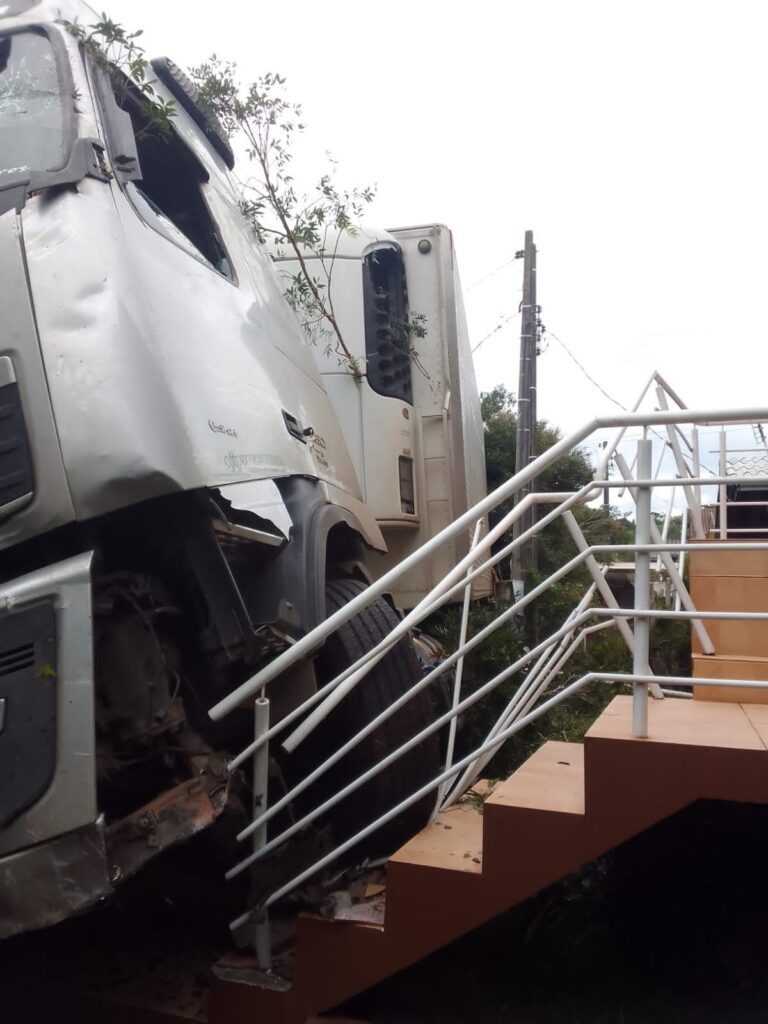 Sem motorista, caminhão desgovernado bate em carro e invade quintal de casas